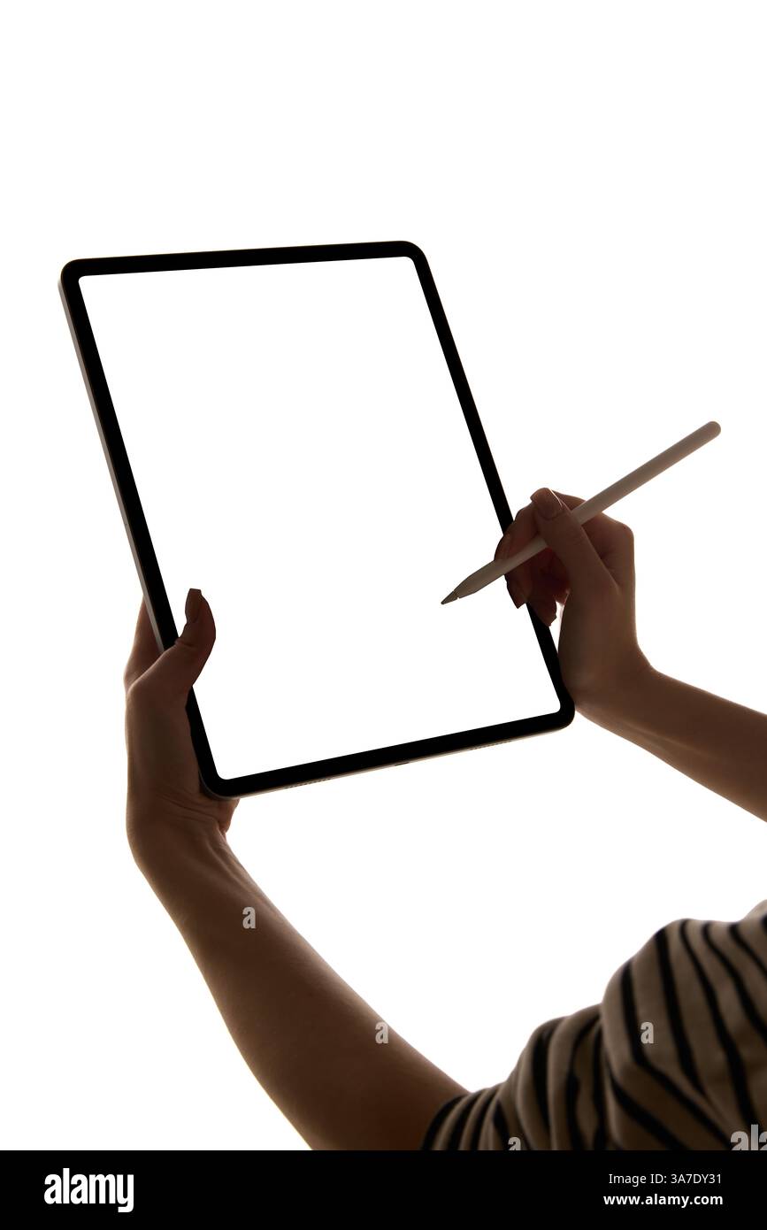 Person holding tablet with blank white screen and using stylus to interact with display against ...