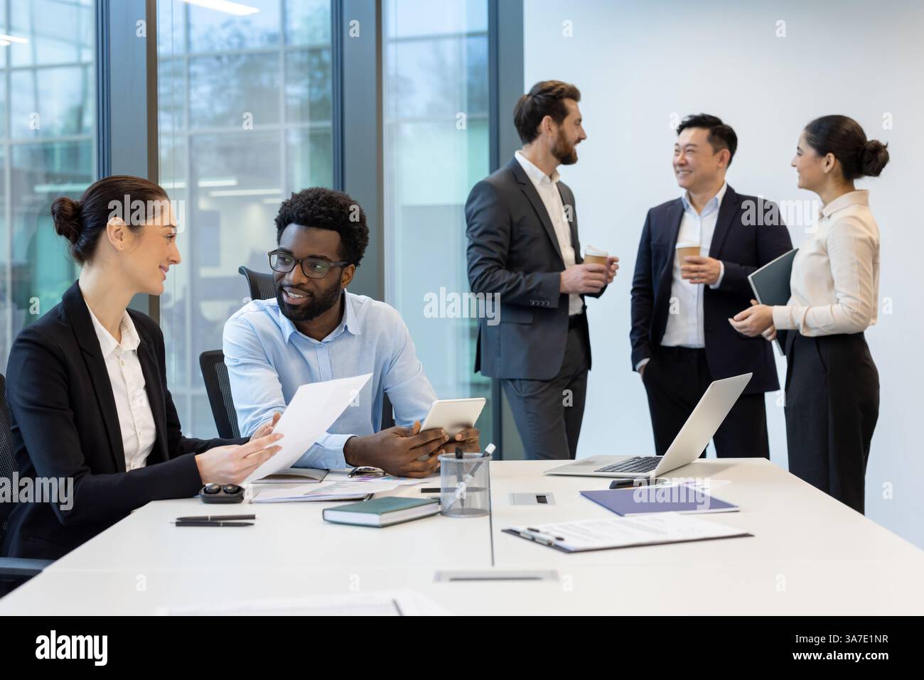 A group of professionals are collaborating and networking during their ...