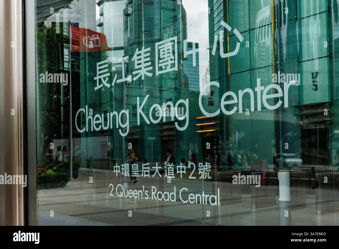 A flag of CK Hutchison seen on the reflection of the glass door of ...