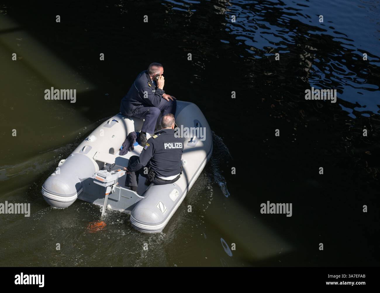 Weilburg, Germany. 27th Mar, 2025. Police officers search the Lahn from ...