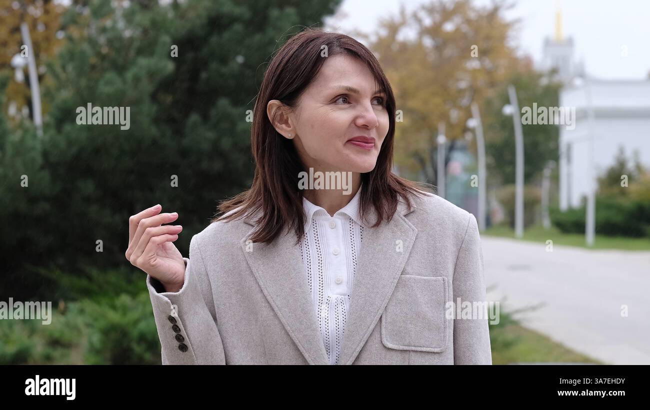 A poised and radiant 50-year-old woman outdoors, embodying the wisdom ...