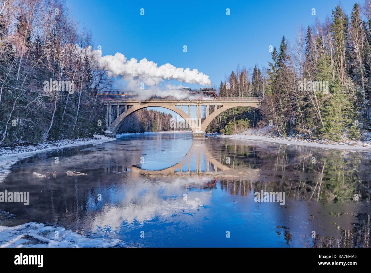 Retro steam train moves above the river Stock Photo - Alamy