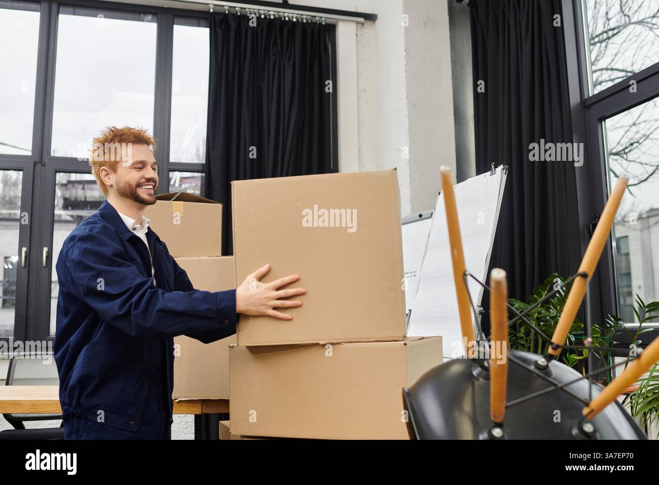 Happy man lifts boxes in a modern office on moving day Stock Photo - Alamy