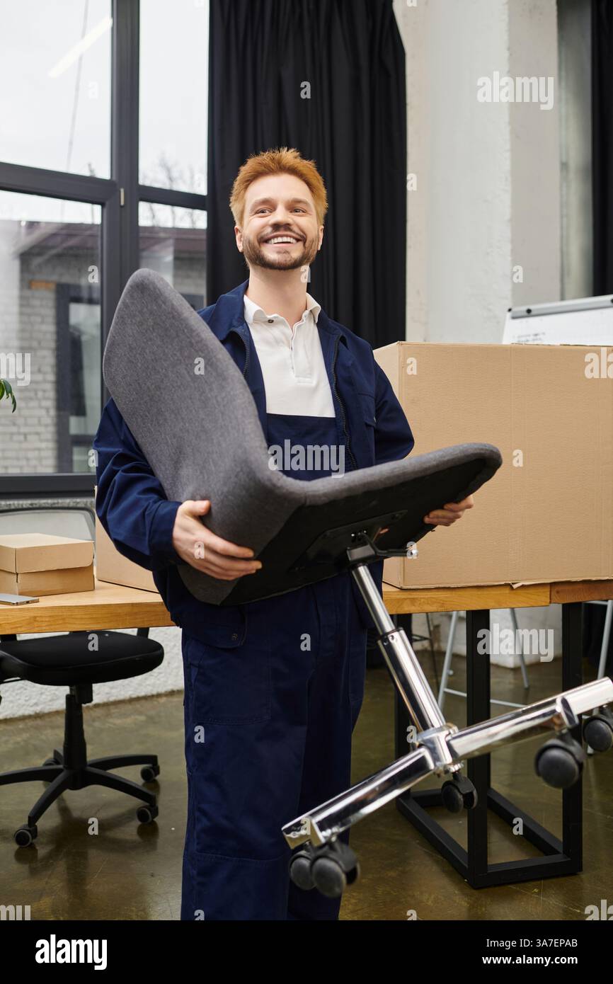 A cheerful man holds an office chair while organizing a modern ...