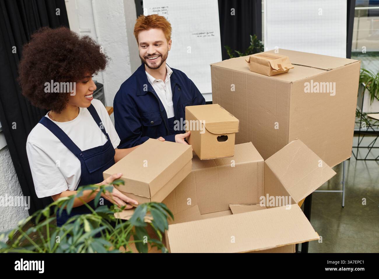 Two friends happily sort and handle various boxes in a contemporary ...