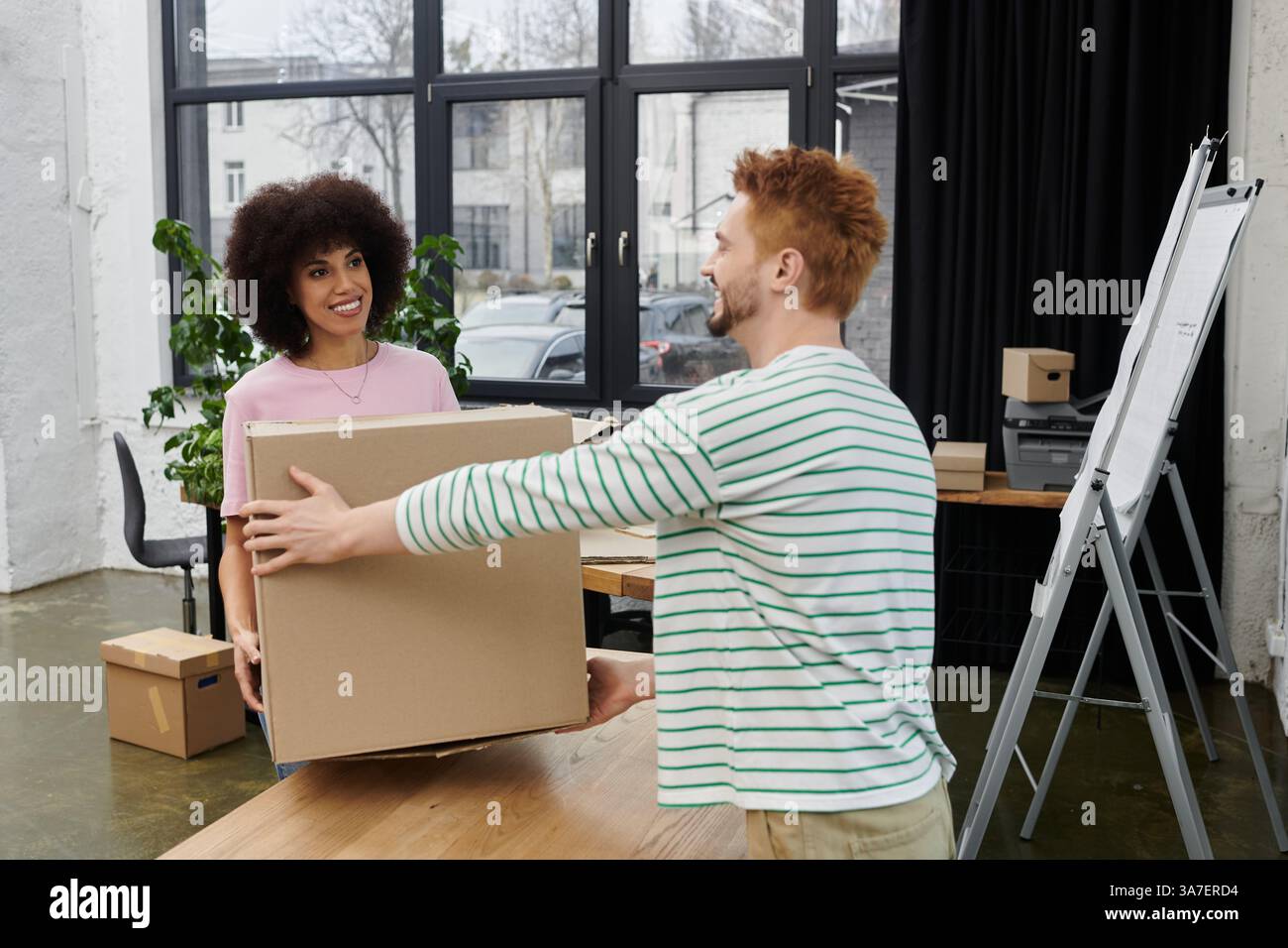 Friends collaborate to pack and unpack boxes in a contemporary office ...