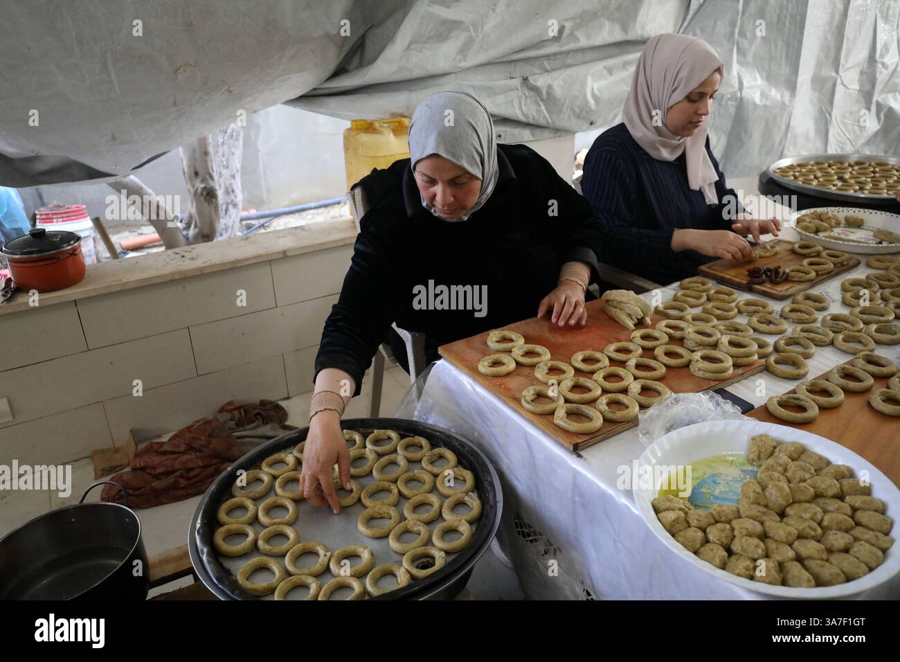 Palestinian families prepare the traditional cookies ahead of Eid al ...