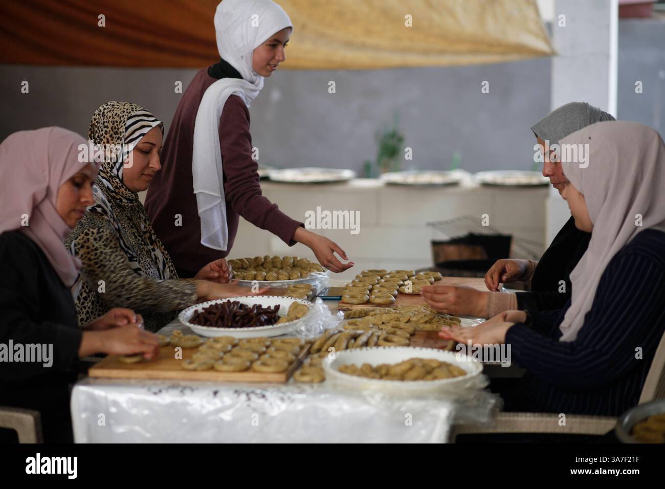Palestinian families prepare the traditional cookies ahead of Eid al ...