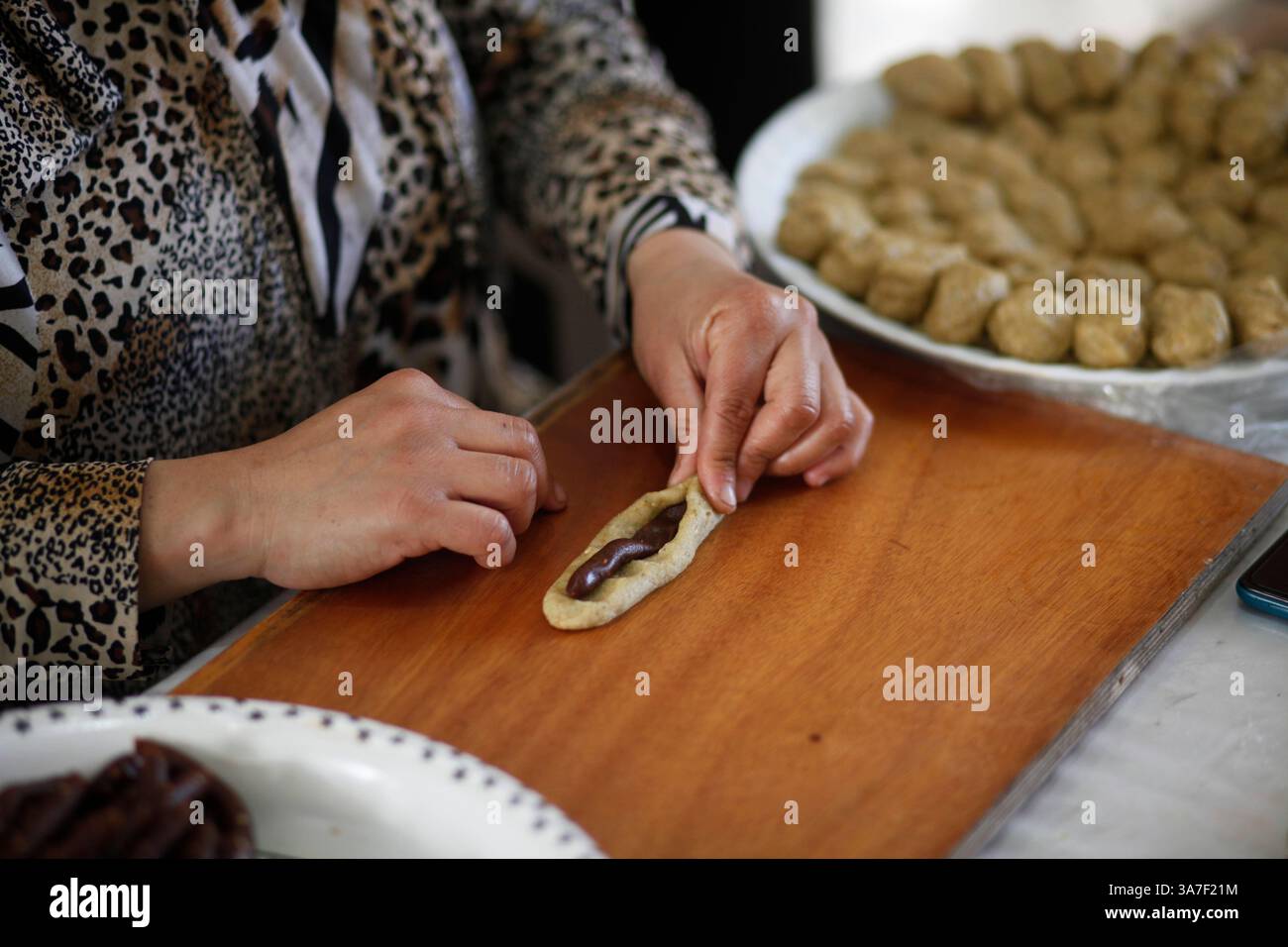 Palestinian families prepare the traditional cookies ahead of Eid al ...