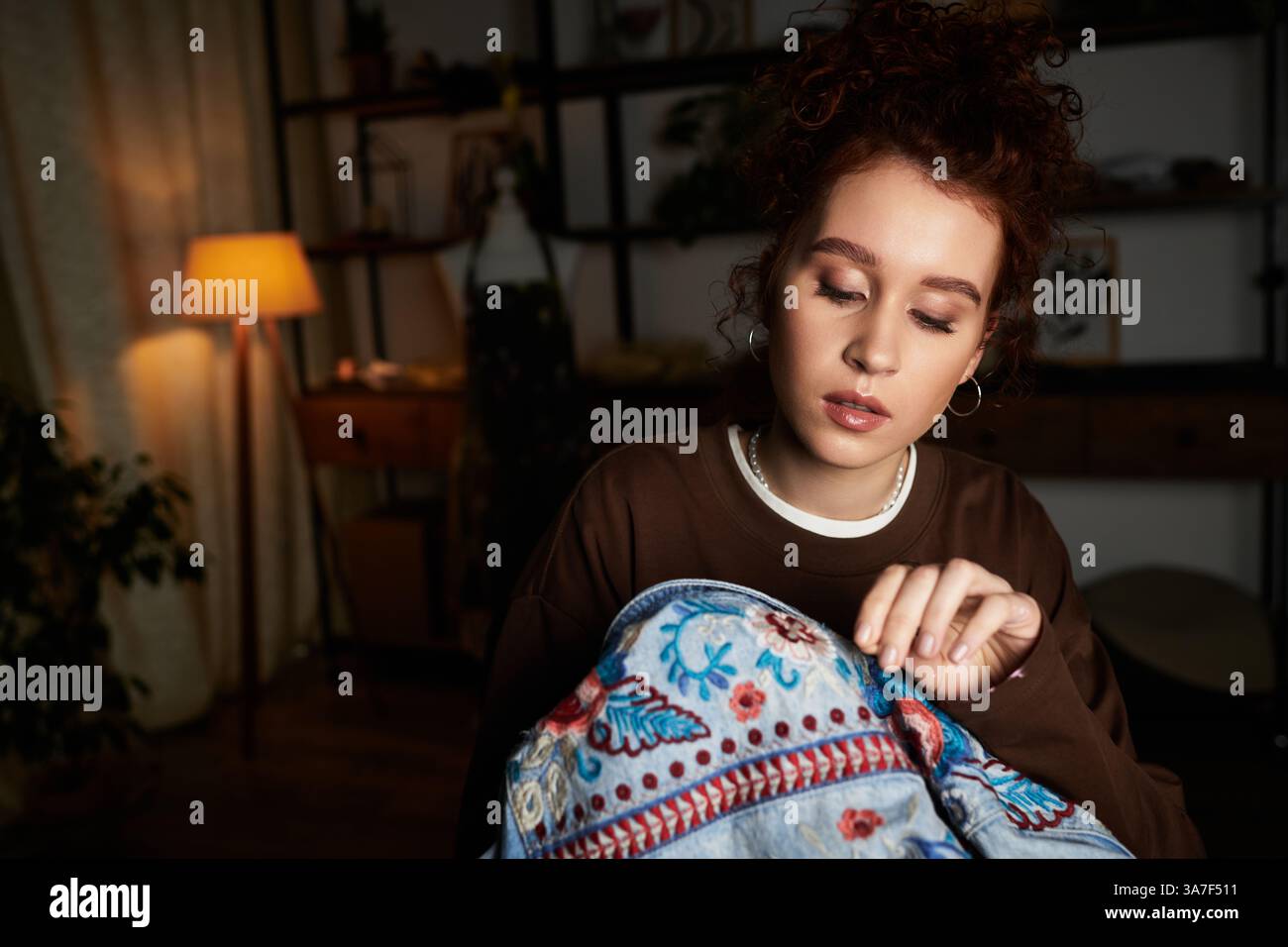 Focused woman meticulously stitches colorful patterns into her DIY ...