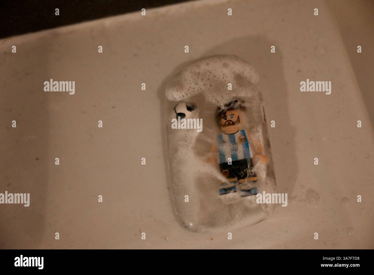 a lego style mini figure of lionel messi encased inside a clear bar of ...