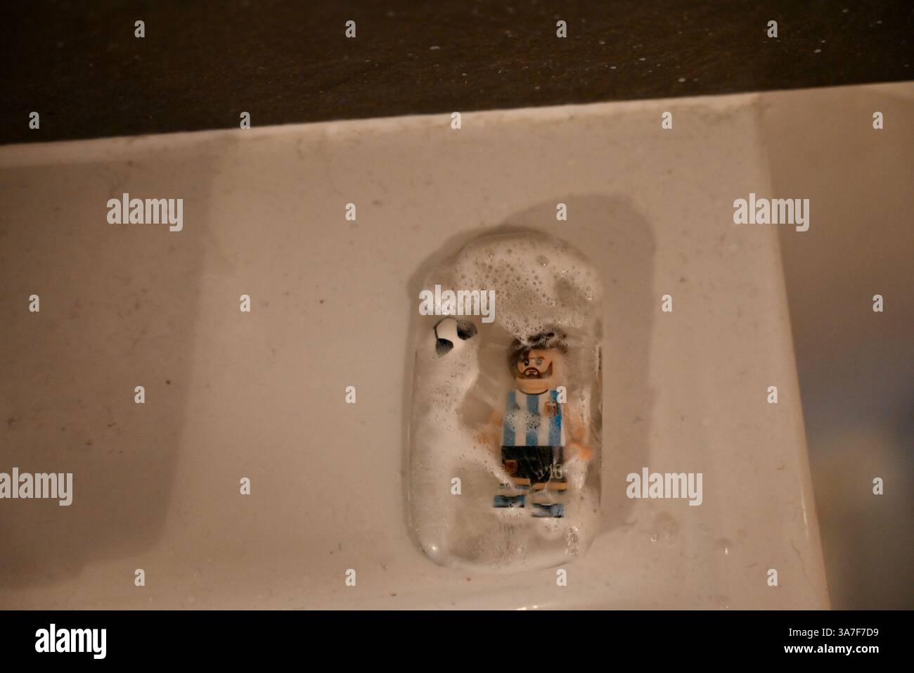 a lego style mini figure of lionel messi encased inside a clear bar of ...