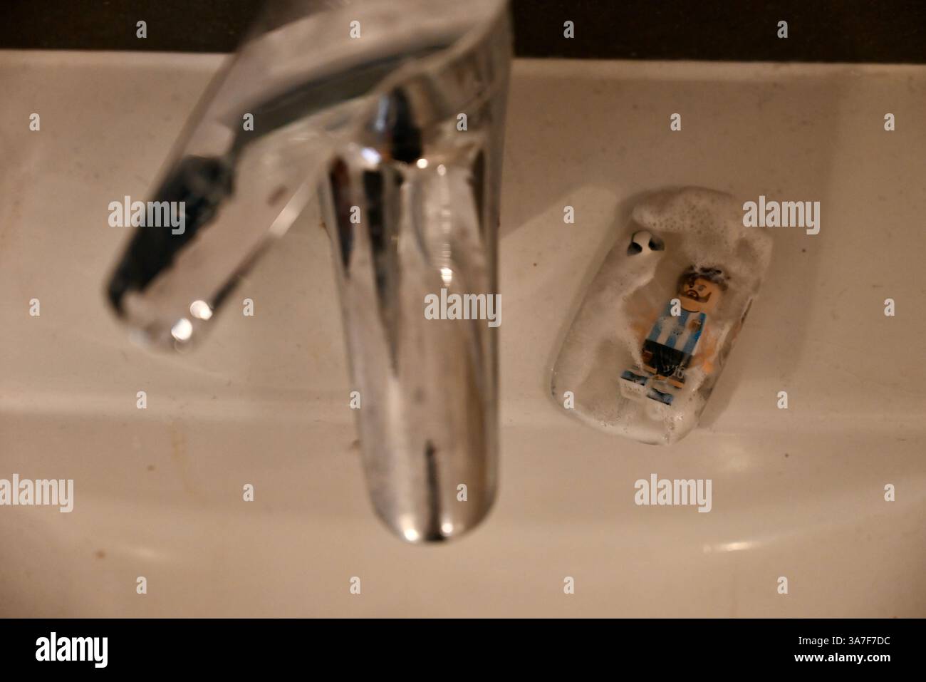 a lego style mini figure of lionel messi encased inside a clear bar of ...