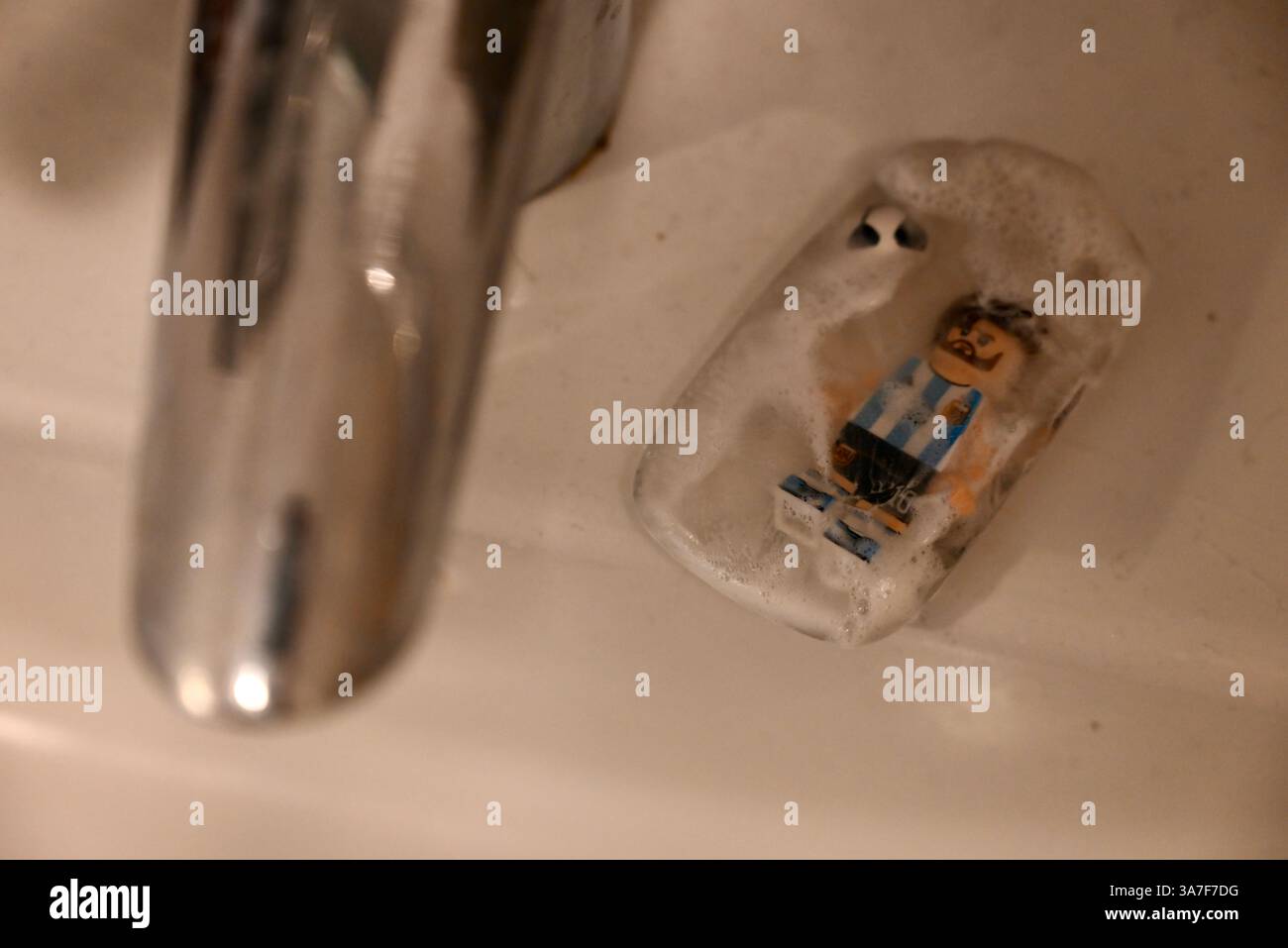 a lego style mini figure of lionel messi encased inside a clear bar of ...