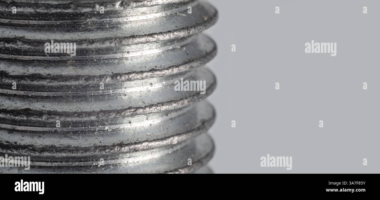 Close-up of metal screw threads with wear against gray background for ...