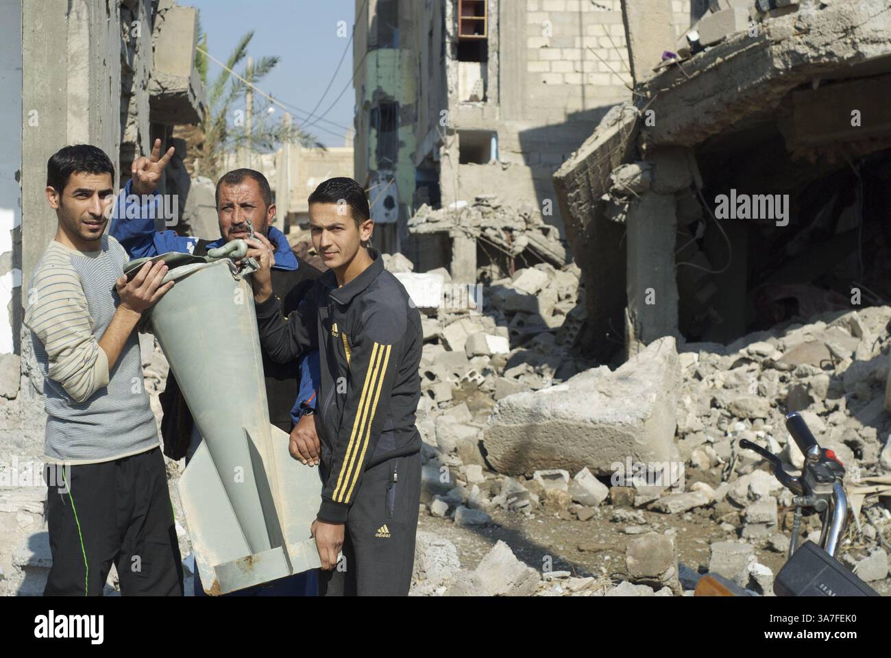 Nov. 21, 2012 - Mayadeen, SYR - Syrian men hoist the remains of a ...