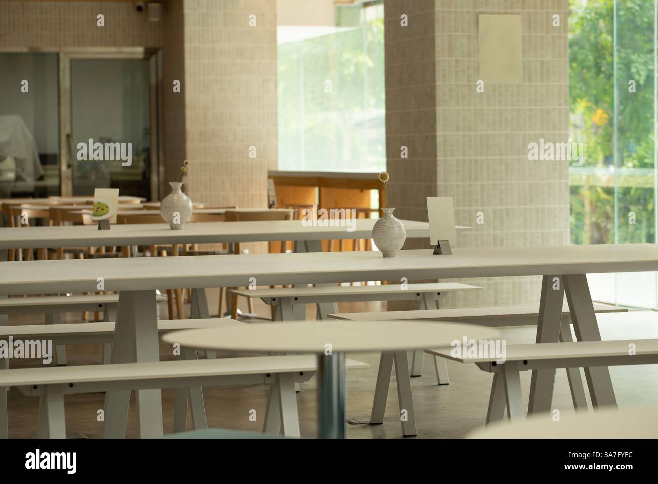 A quiet cafe scene displays rows of clean, white tables with unique ...