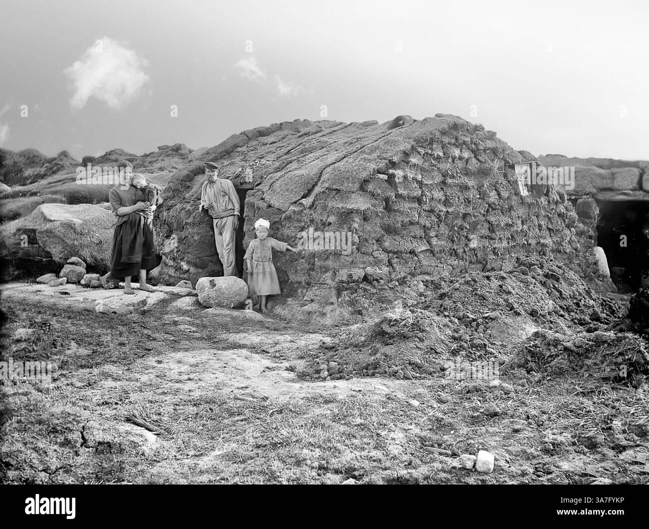 A family outside their temporary turf hut after being evicted from ...