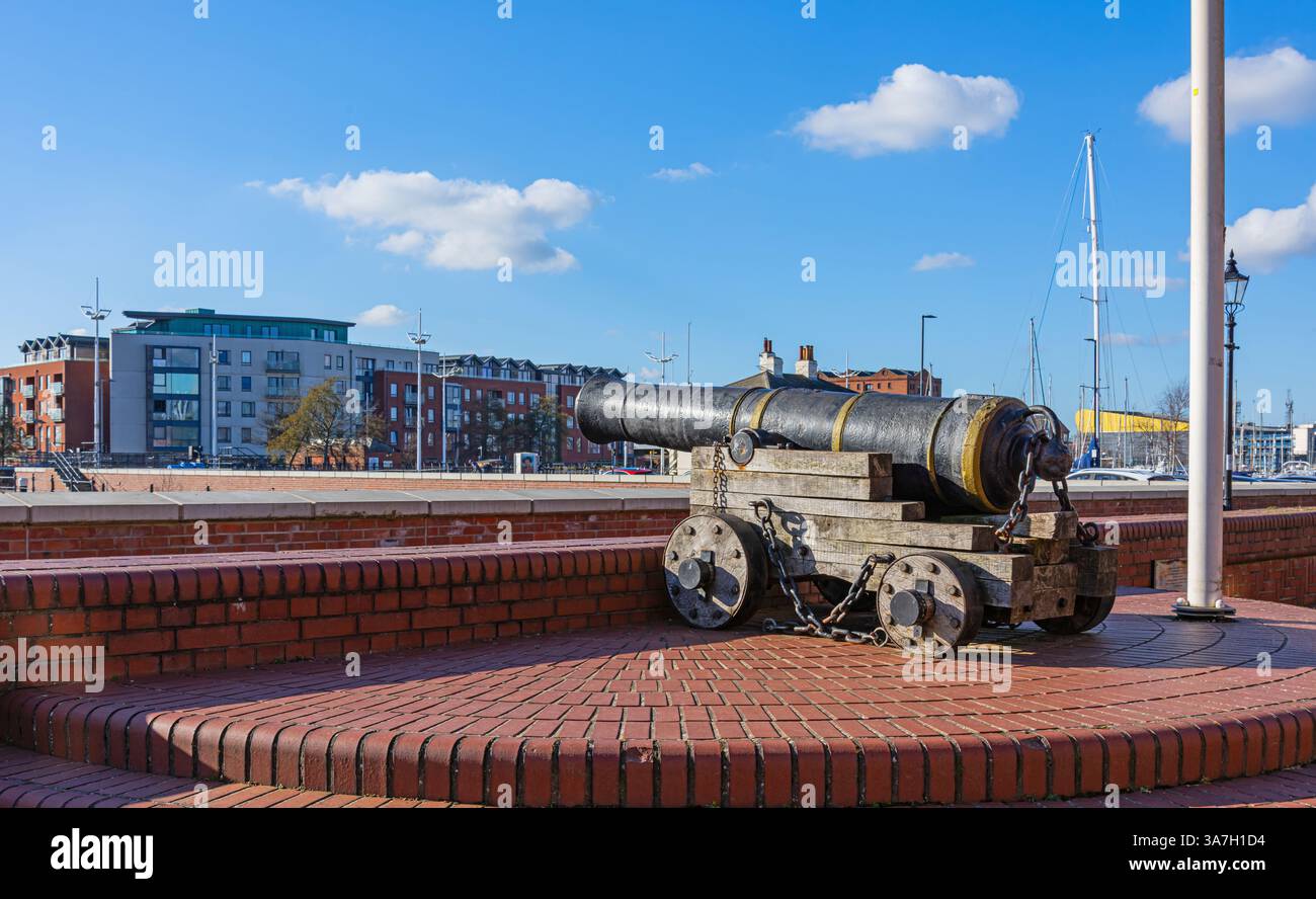 An old cannon displayed on a raised brick mounting in a marina. There ...