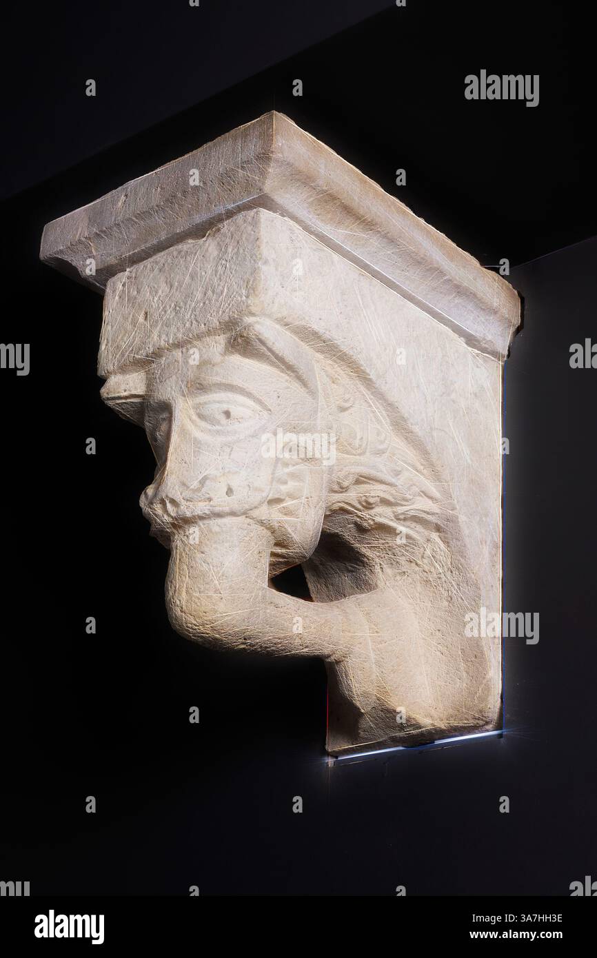 An intricately carved stone corbel featuring a stylized animal head ...