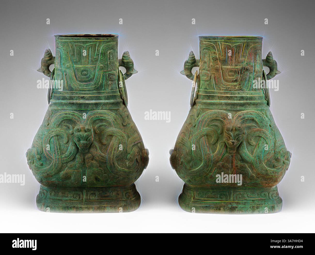 Two intricately designed ancient bronze vessels stand side by side ...