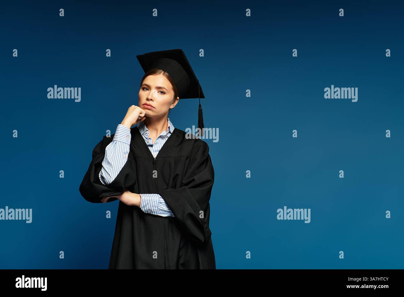 Celebrating academic achievements, a young woman in a graduation gown ...