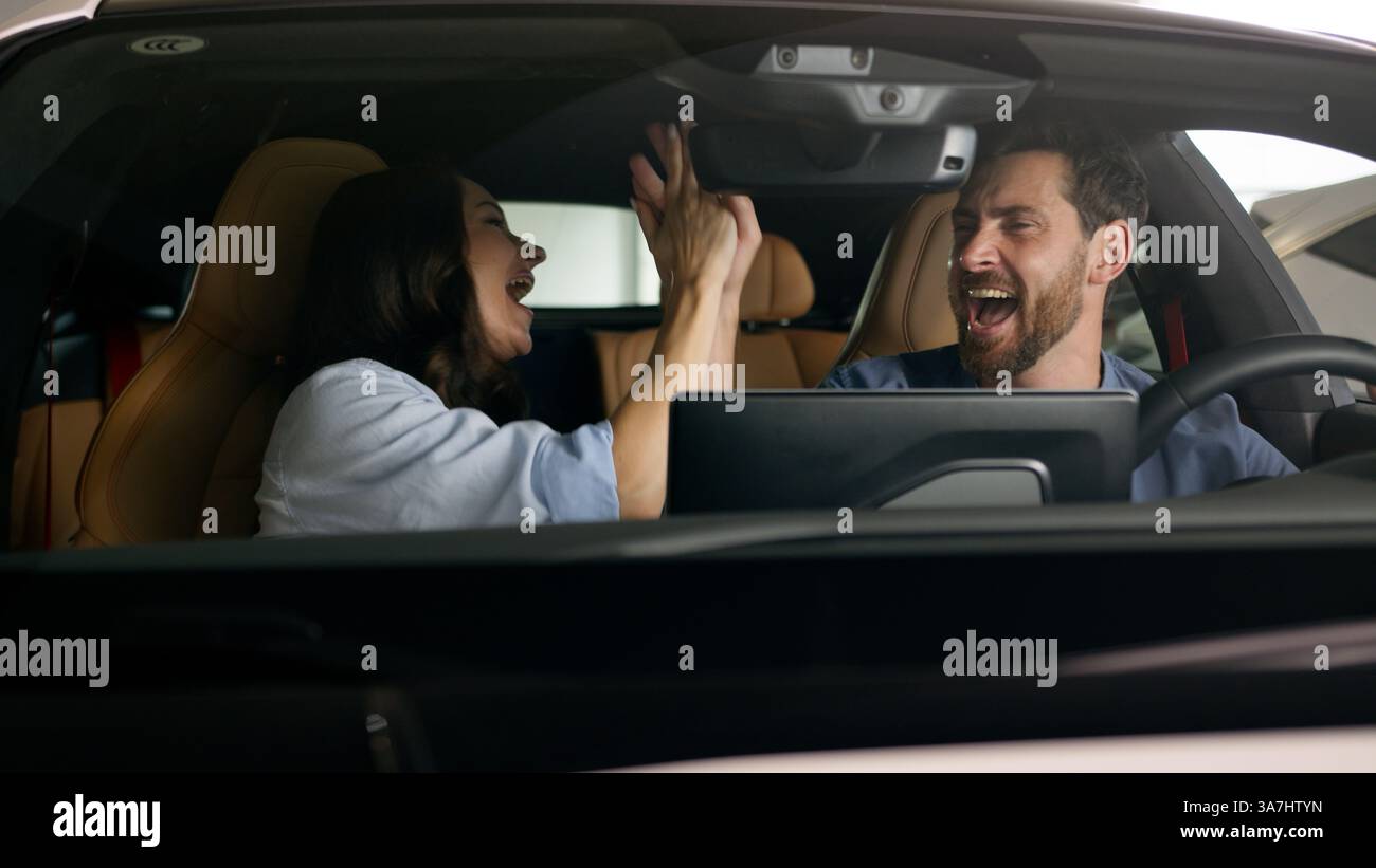 Caucasian couple dancing happy inside automobile celebrate buying auto ...