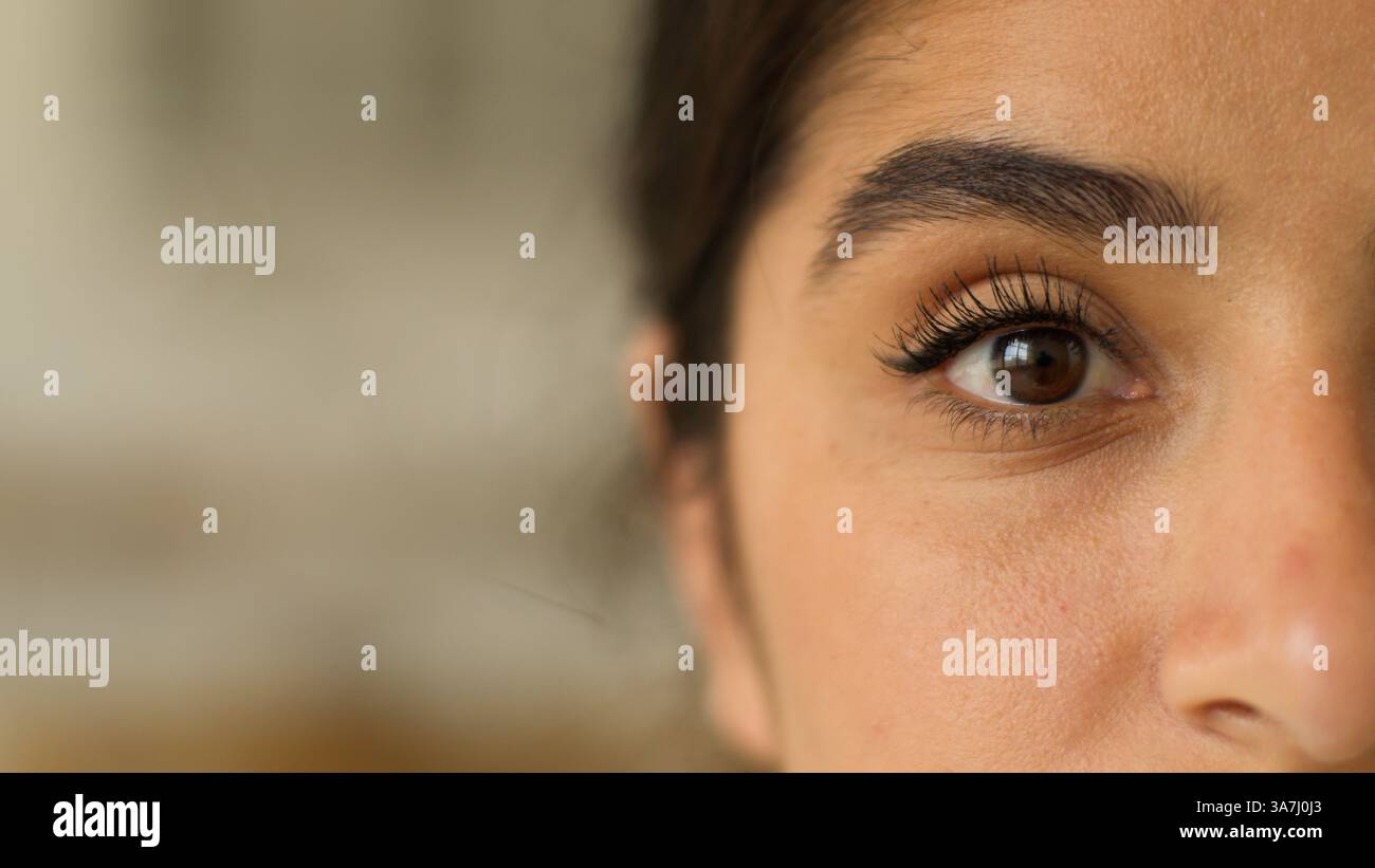 Extreme close up half face calm dark eye Indian Arabian woman cropped ...