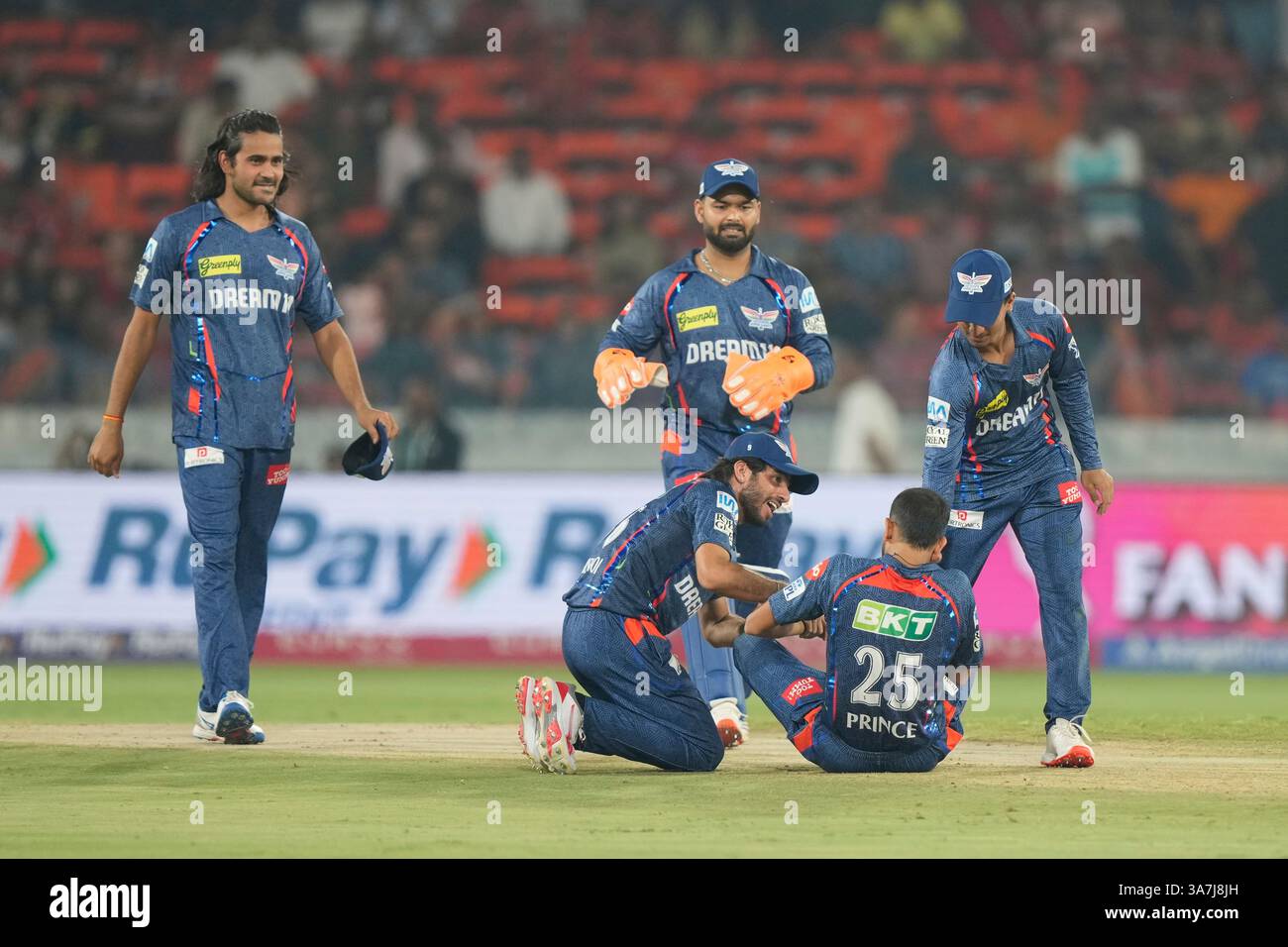 Lucknow Super Giants' Prince Yadav reacts after a ball hit on his hand during the Indian Premier ...