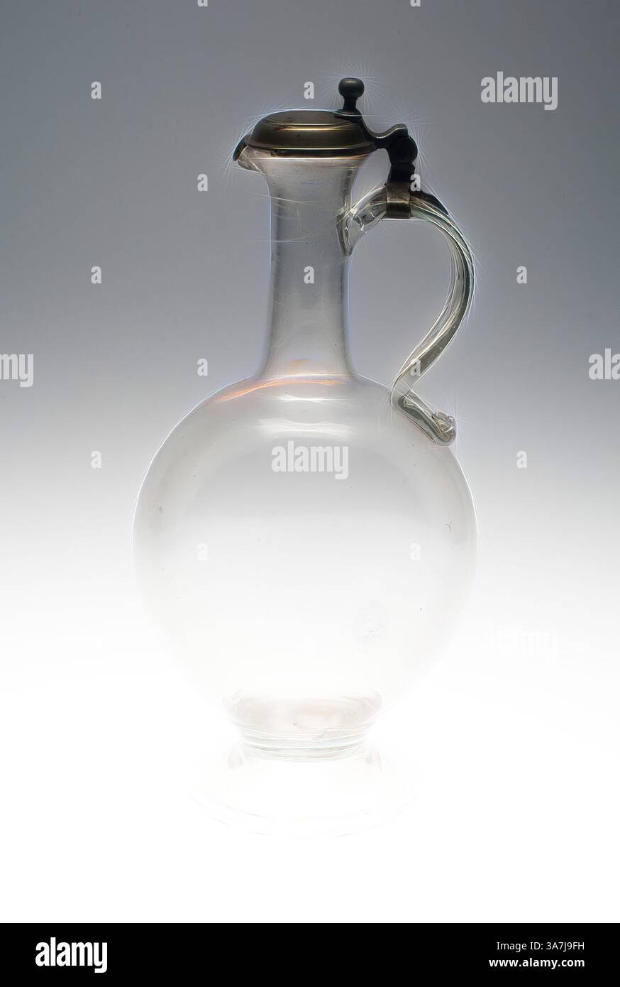 A beautifully shaped glass jug with a slender neck and a decorative lid ...