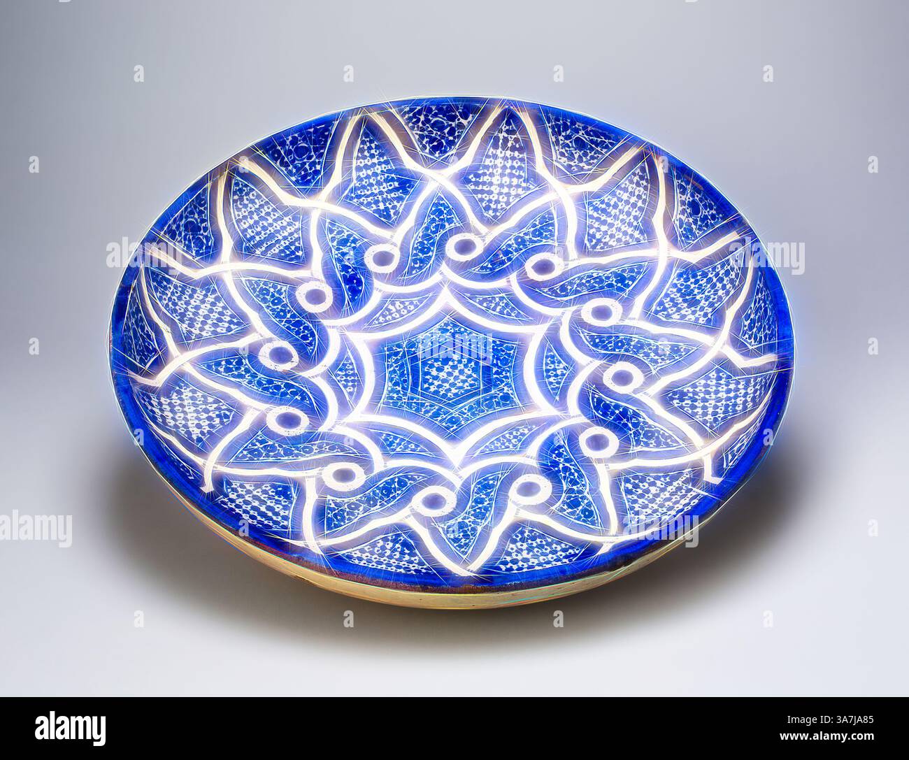 An intricately designed ceramic plate featuring a vibrant blue and ...