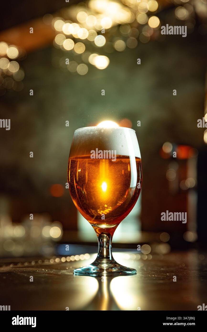 Shimmering golden beer in elegant glass with festive sparkle and ...