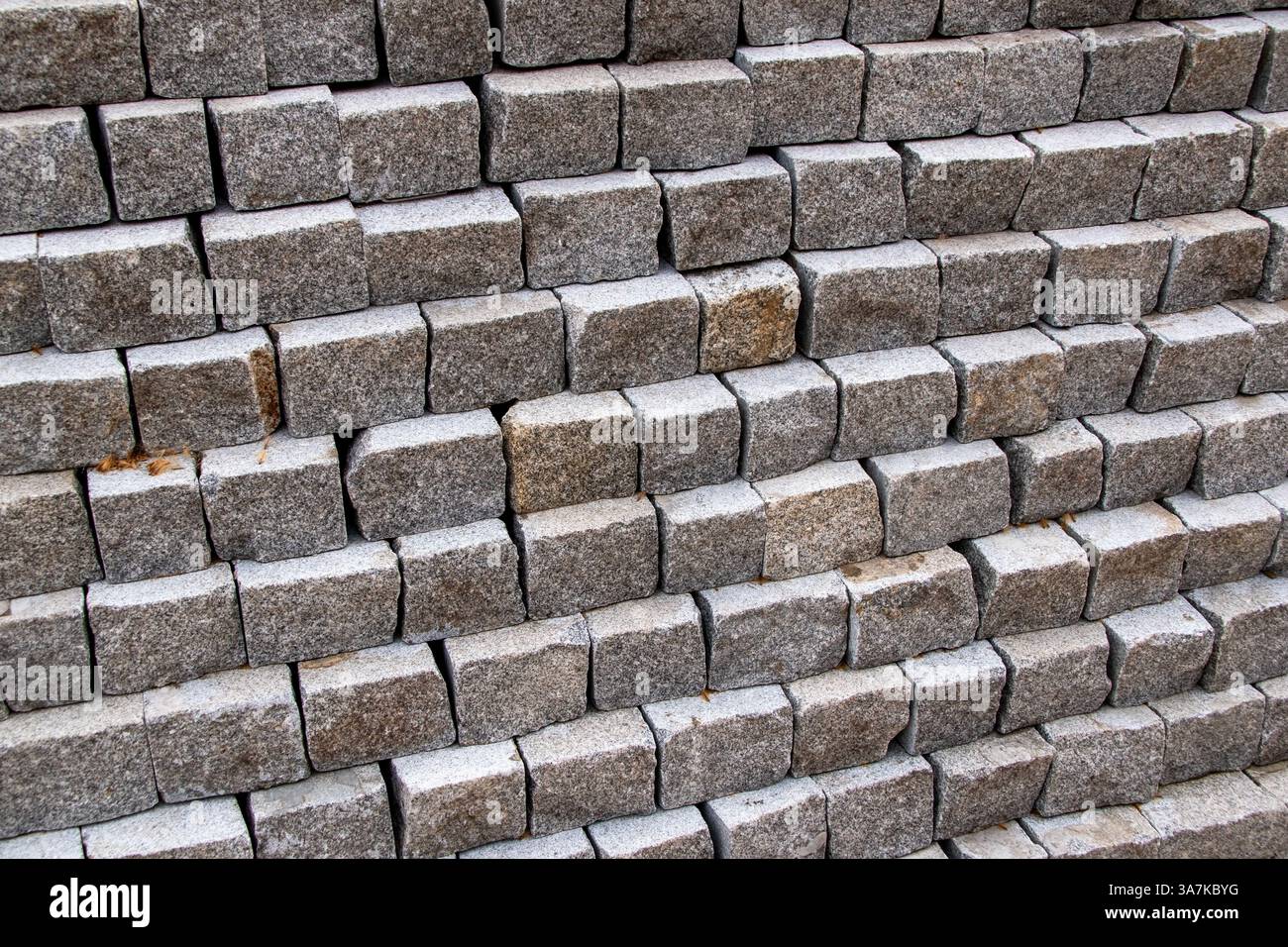 Gray stone bricks stacked in a row for construction. Background texture ...