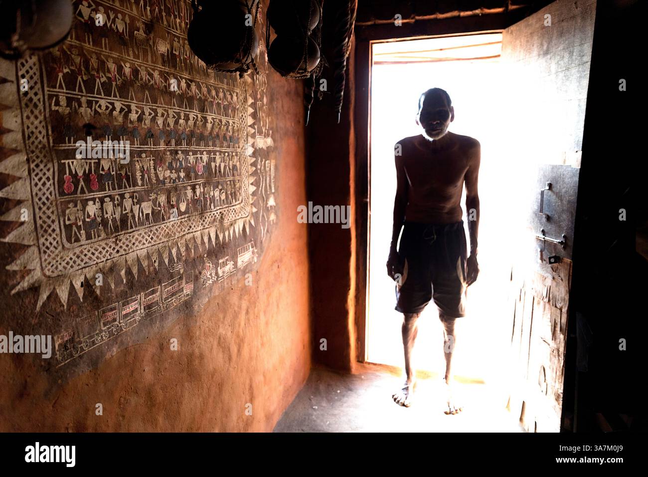 Man standing infront of a Traditional paintings, drawings on a wall of ...