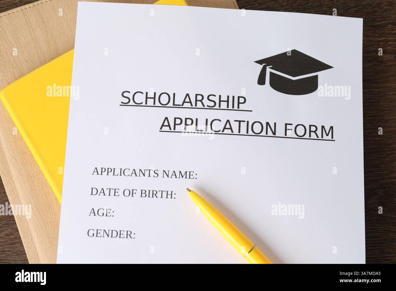 Scholarship application form, pen and notebooks on table, top view ...