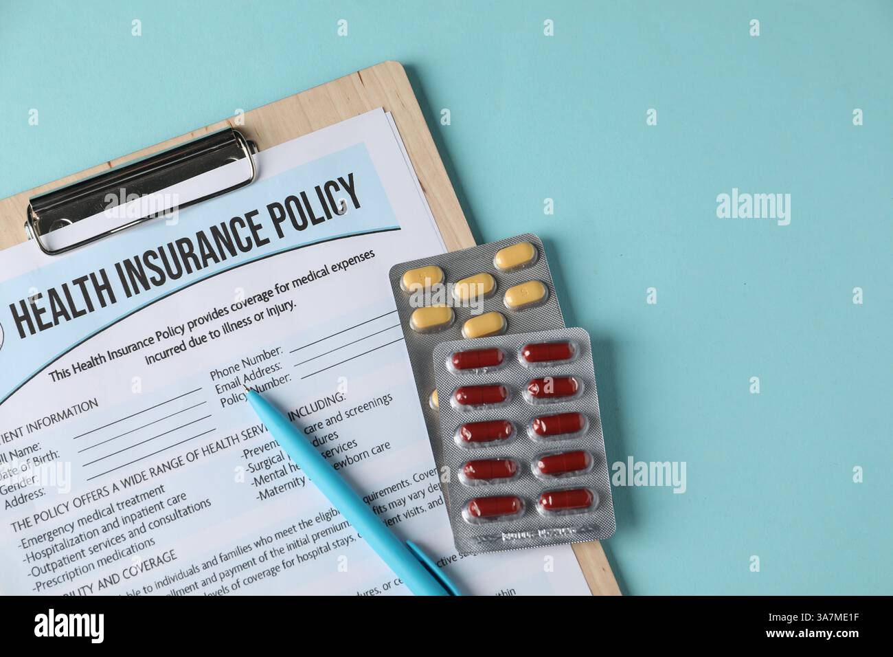 Health insurance policy, pen and pills on turquoise background, top ...