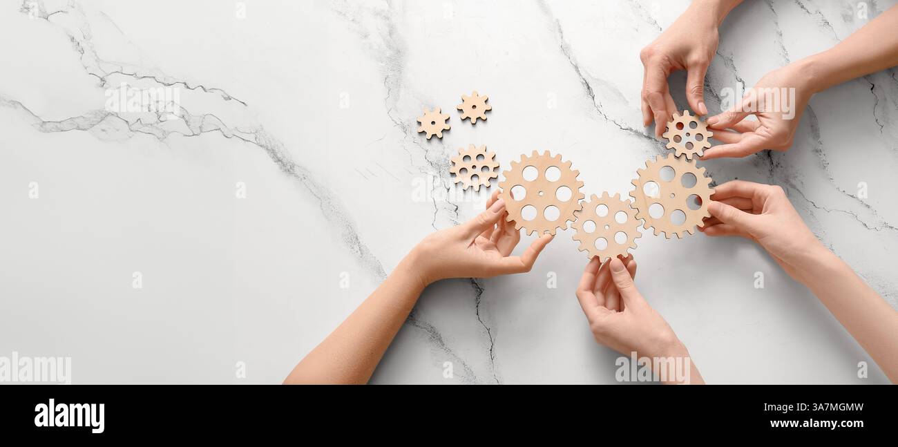Hands and wooden gears on light background with space for text, top ...