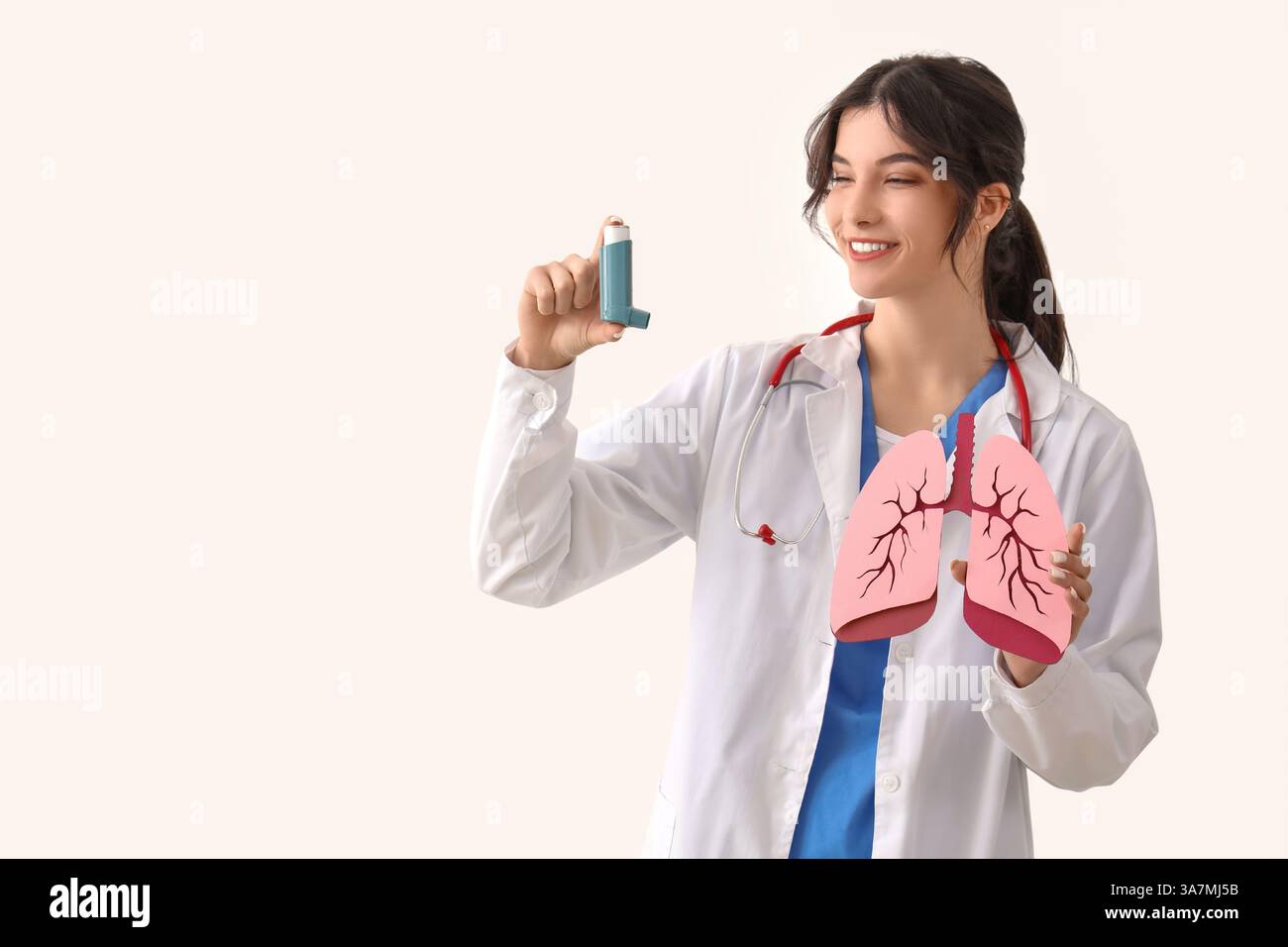 Female doctor with paper lungs and asthma inhaler on white background ...