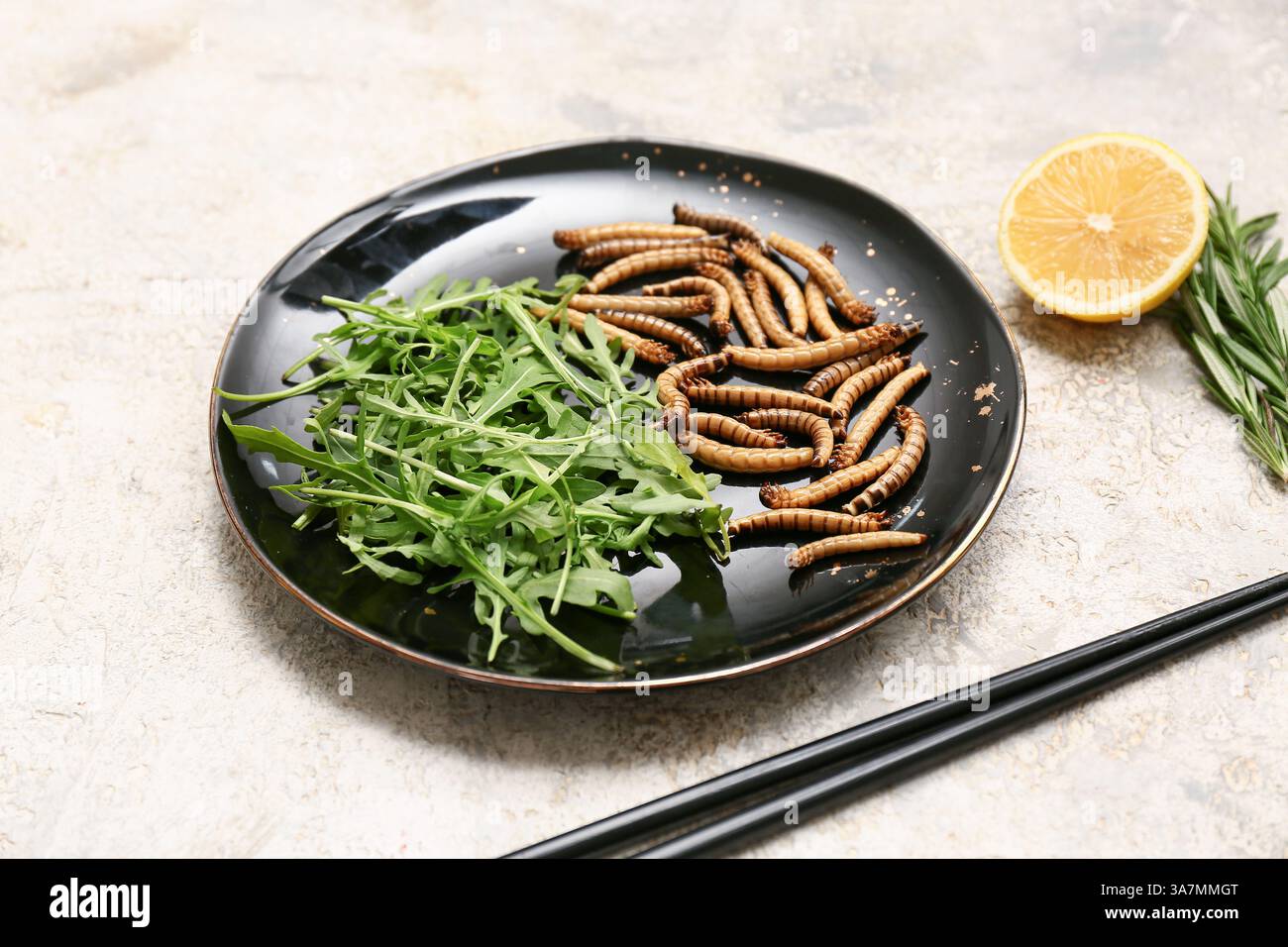 Plate of fried maggots with arugula and lemon on white background Stock ...