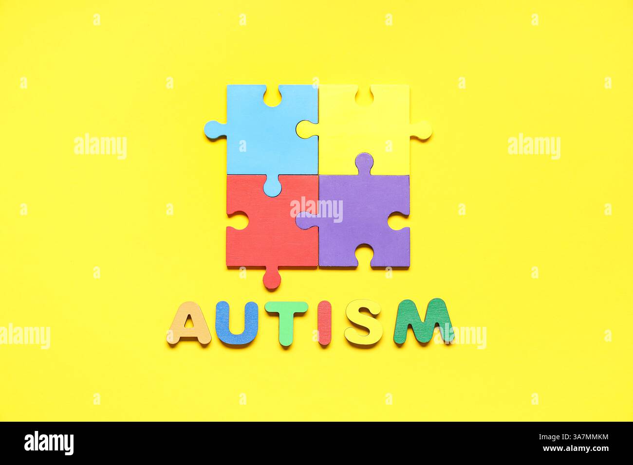 Word AUTISM with colorful puzzle pieces on yellow background. Autistic ...