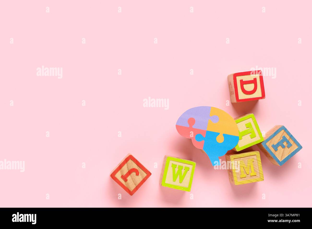 Play cubes with colorful puzzle pieces in shape of brain on pink ...