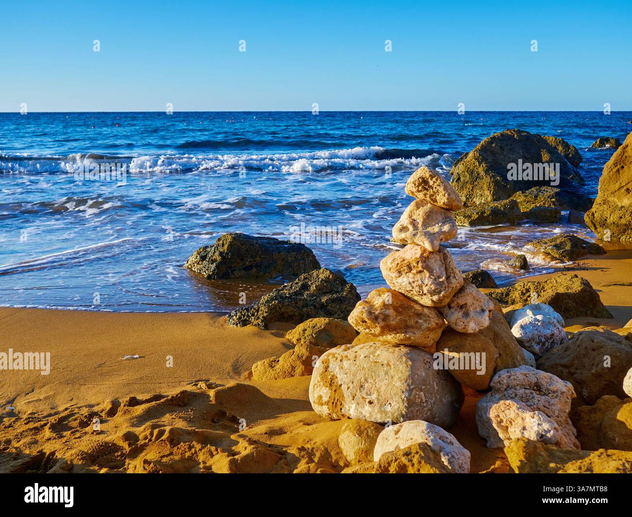 Pile of stones on the beach at Ramla Bay, Malta Stock Photo - Alamy
