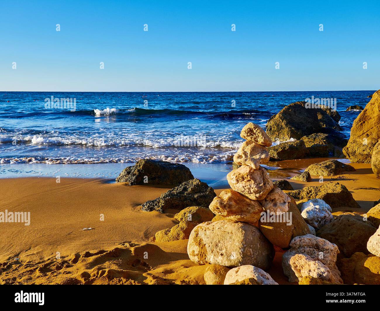 Pile of stones on the beach at Ramla Bay, Malta Stock Photo - Alamy