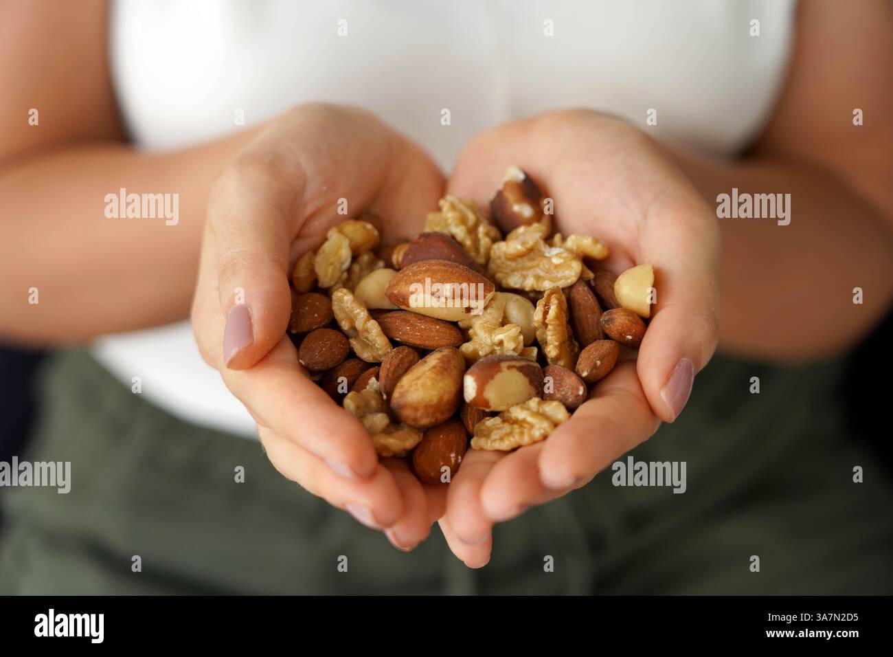 World health day. Woman hands showing a variety of nuts mix of dried ...