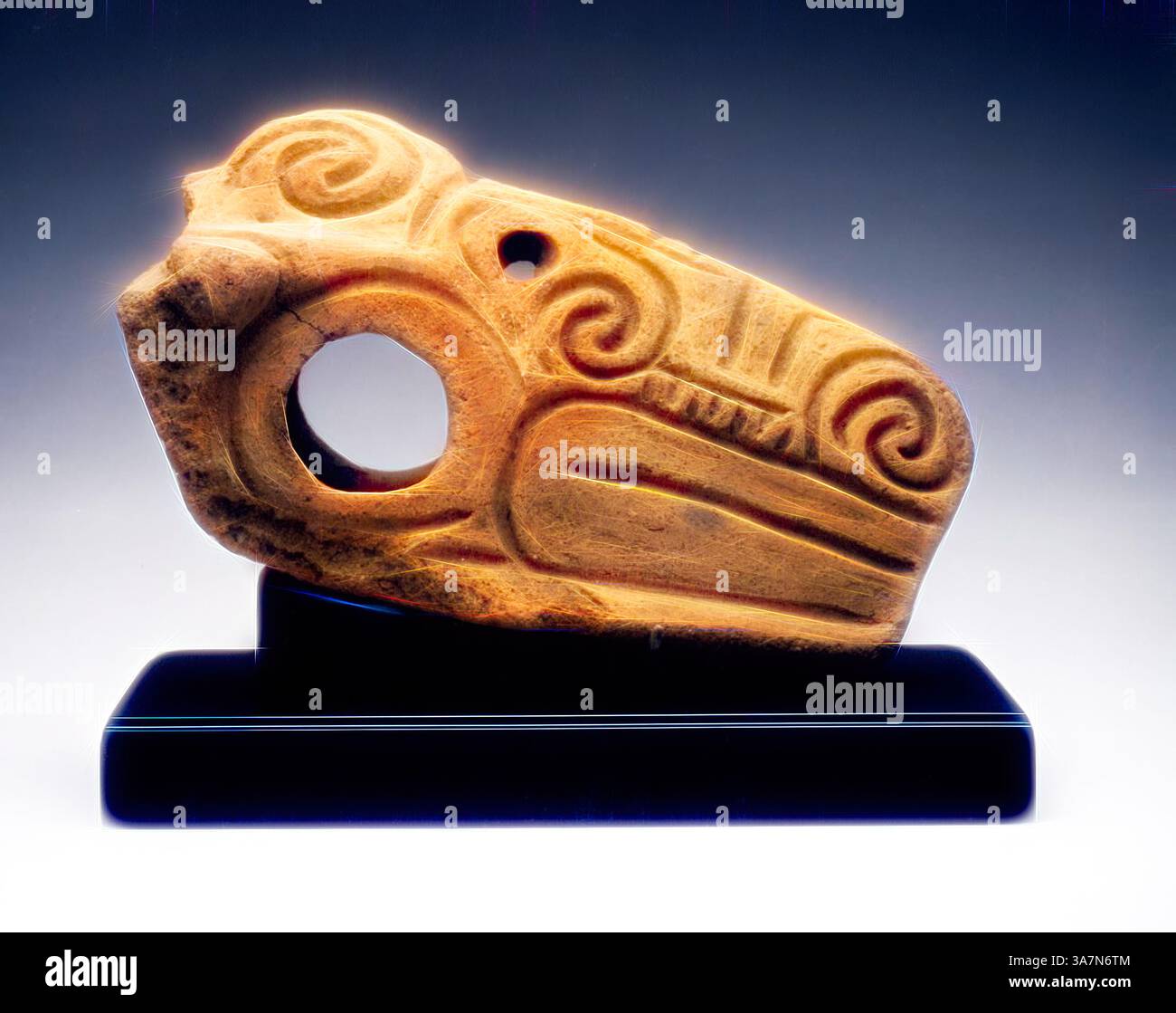 An intricately carved artifact featuring curved lines and circular ...