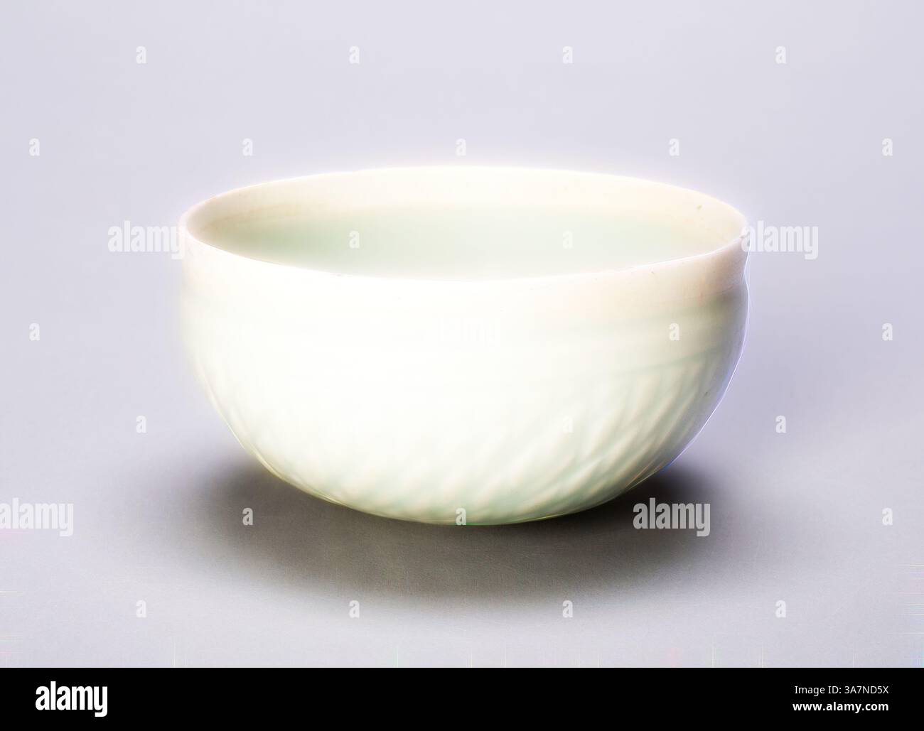 A delicate, pale ceramic bowl with a subtle textured pattern on the ...