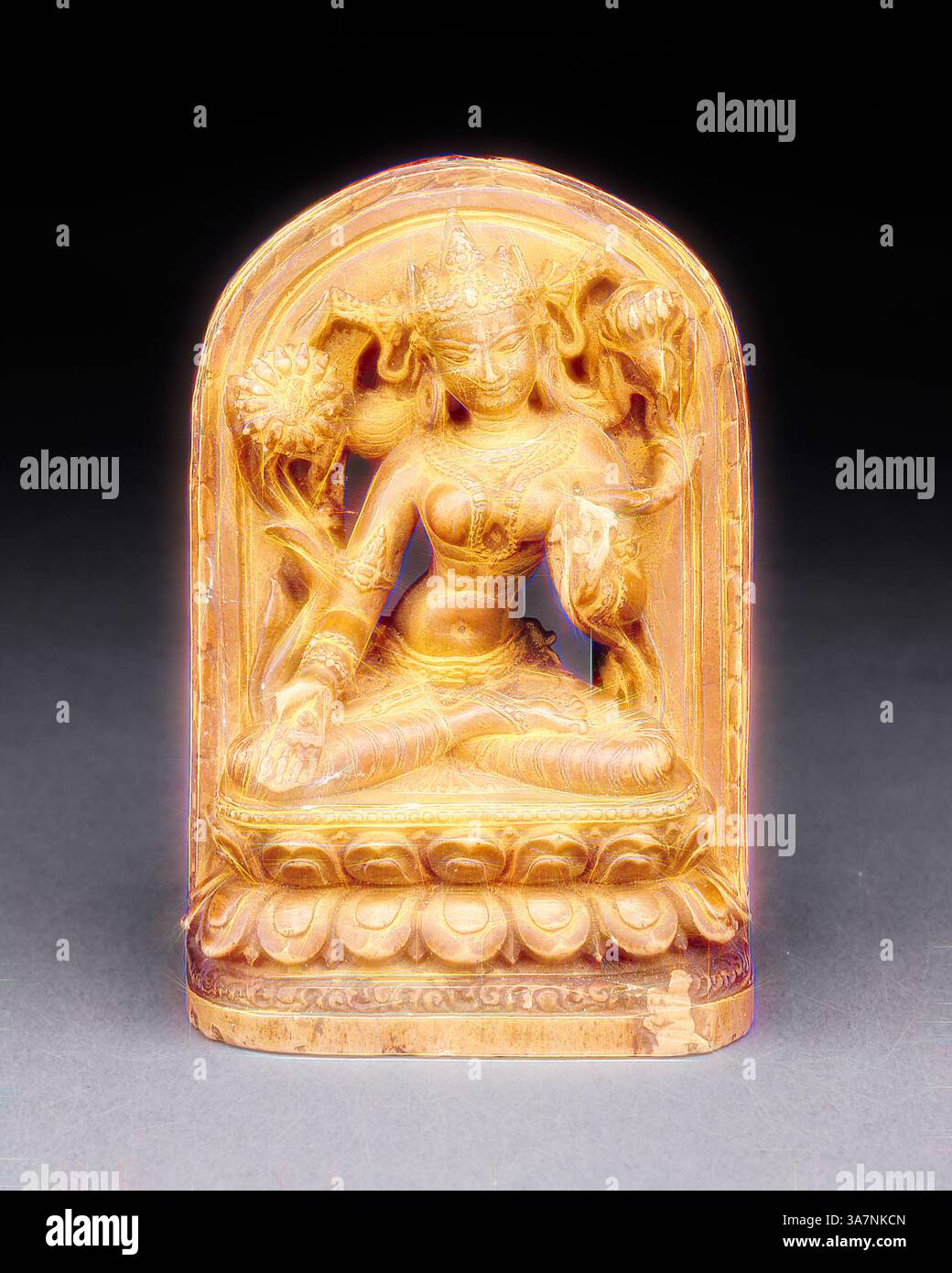 A beautifully carved figure of a goddess, seated in a meditative pose ...