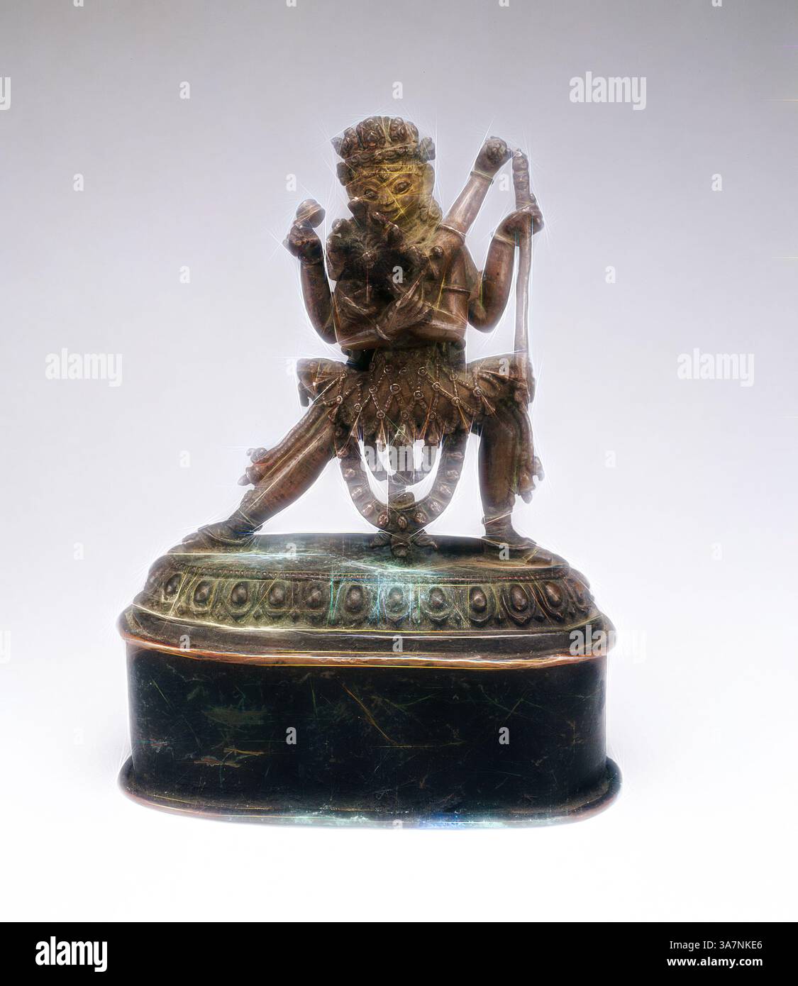 A seated figure with intricate details, adorned in ornate clothing and ...