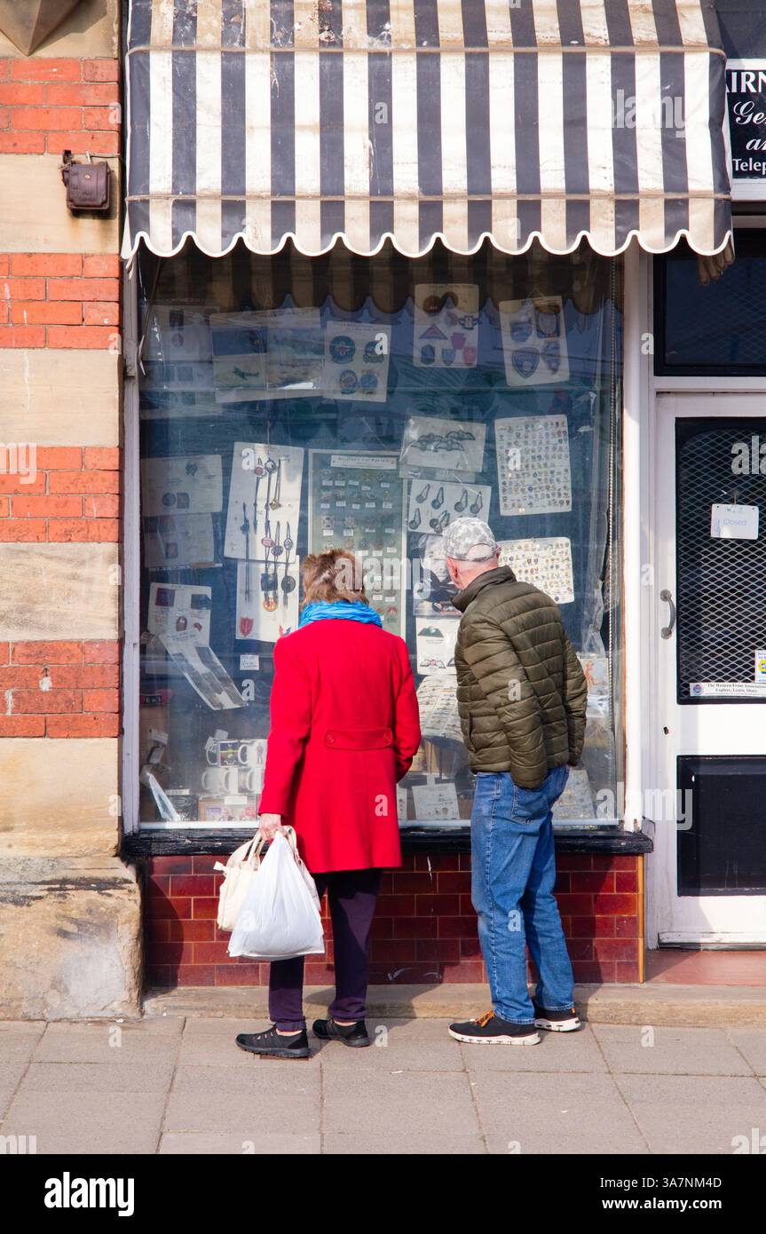 An older couple looking in the window of Cairncross and sons shop in ...