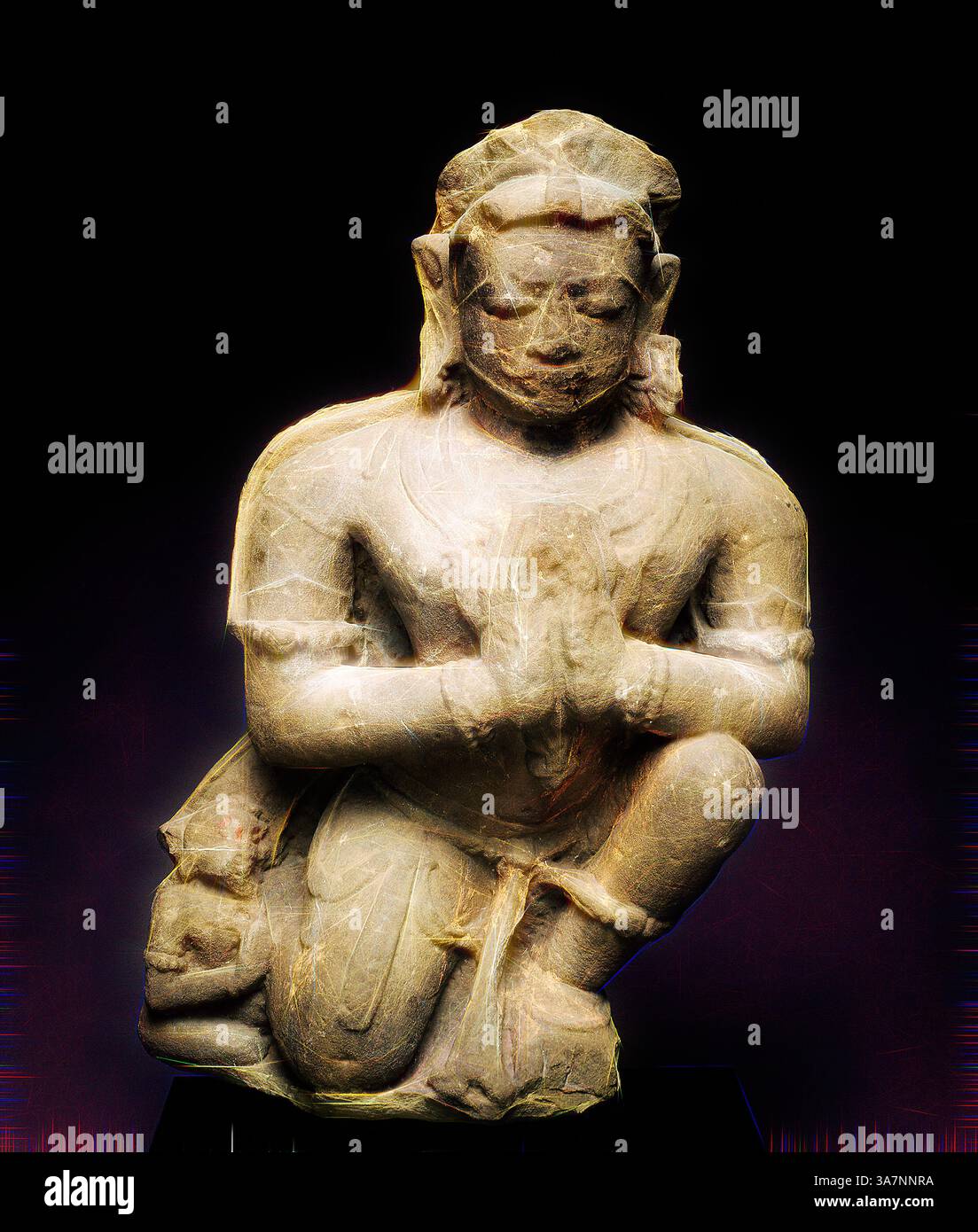 A detailed stone sculpture of a kneeling figure with hands in a prayer ...